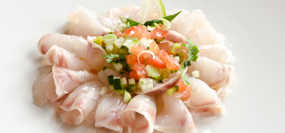 Carpaccio di branzino con pomodoro, peperone, cetriolo, lime e coriandolo